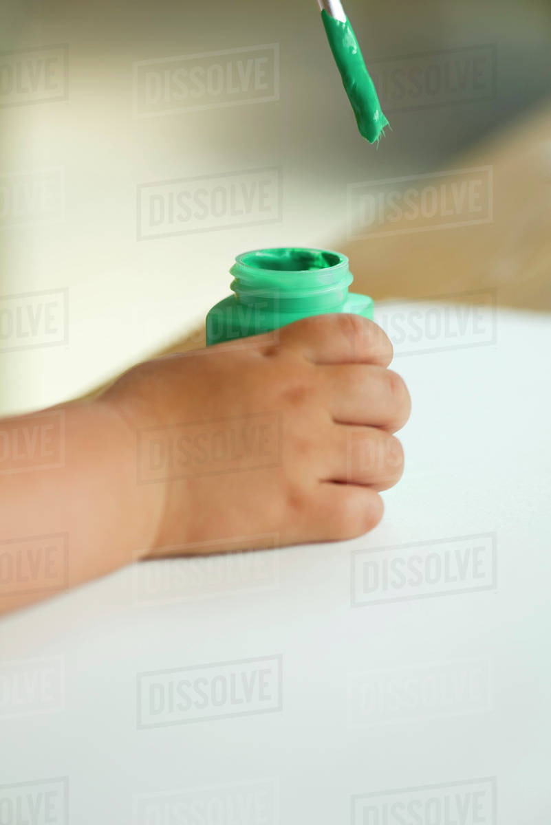 Child dipping paintbrush into paint, cropped - Royalty-free Stock Photo ...