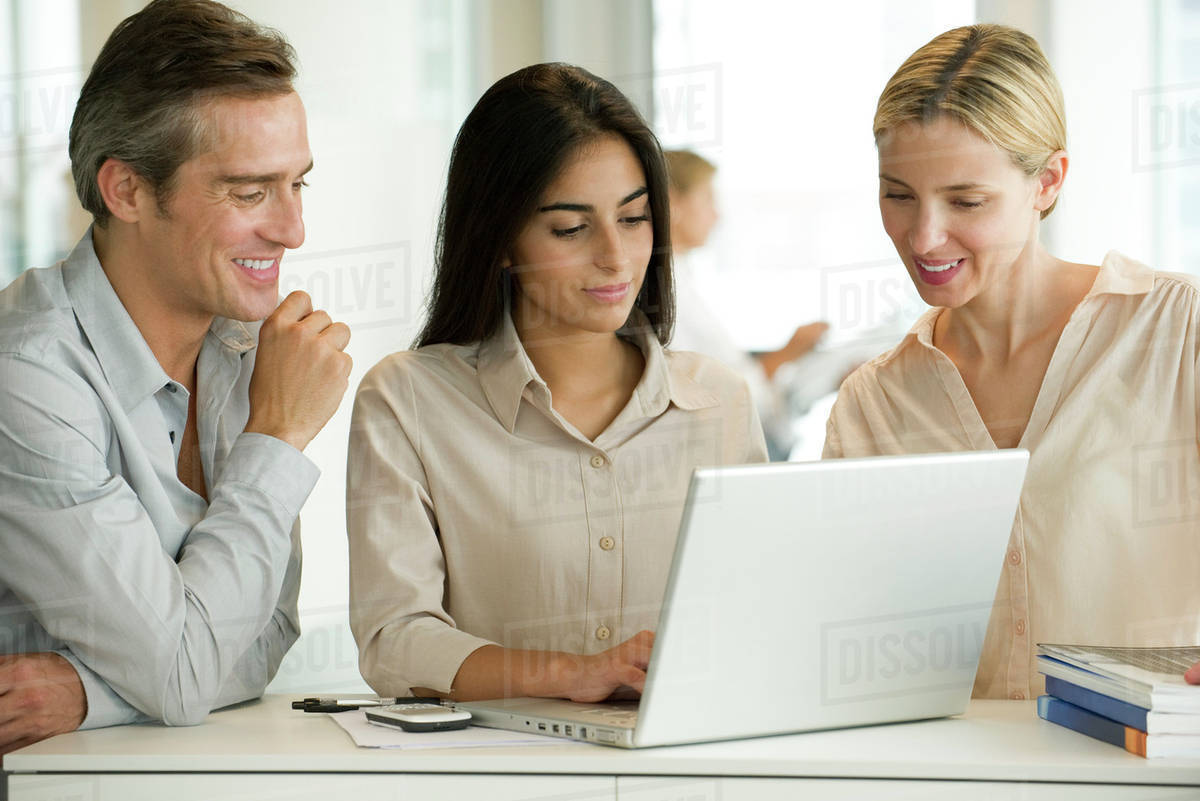 Colleagues working together on laptop computer - Royalty-free Stock ...