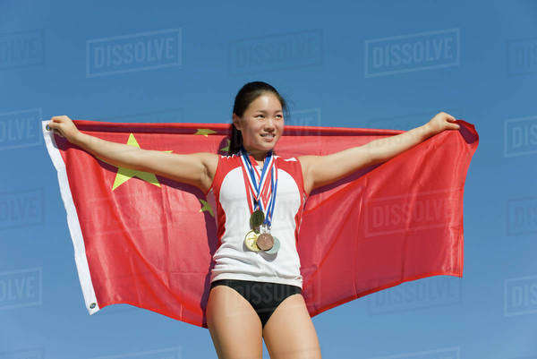 Female athlete on winner's podium, holding Chinese flag - Royalty-free ...