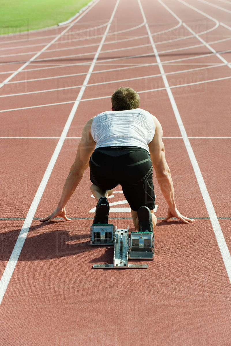 Runner crouched at startling line, rear view - Royalty-free Stock Photo ...