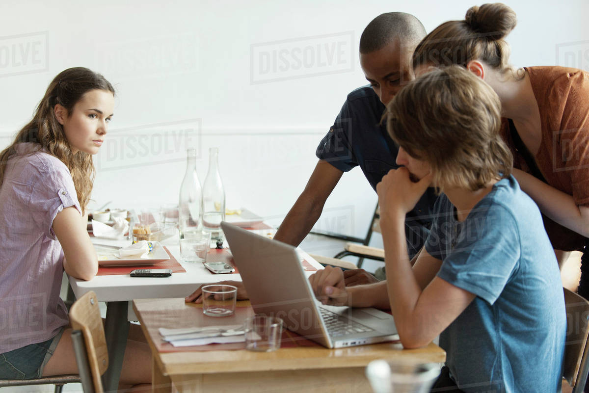Young woman watching friends using laptop computer - Royalty-free Stock ...