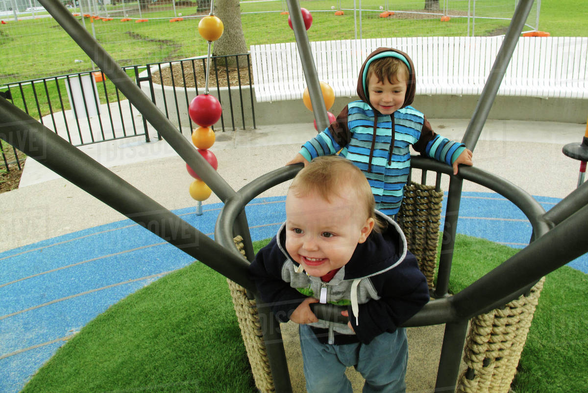 Toddler boys playing on playground - Stock Photo - Dissolve