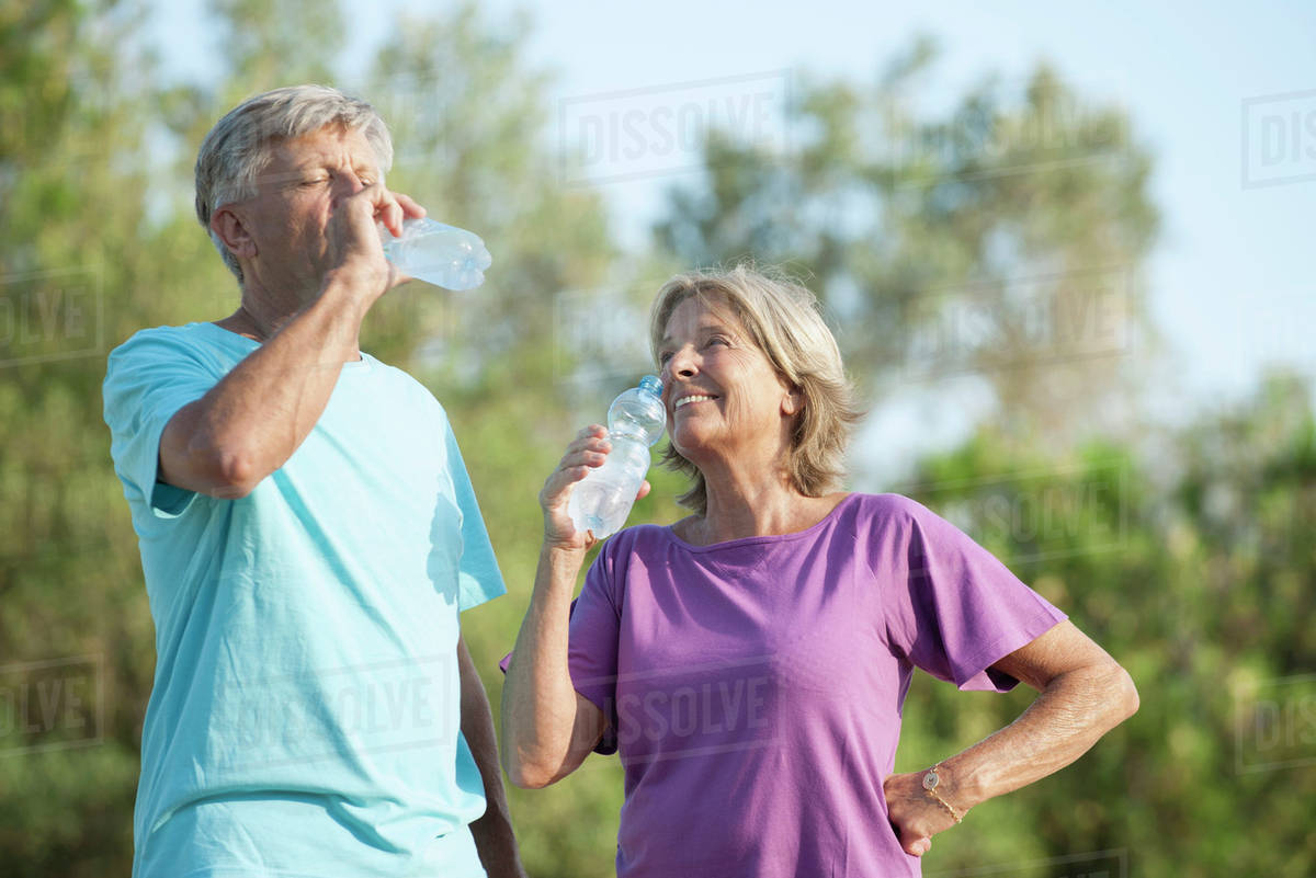 Senior couple drinking bottled water outdoors - Royalty-free Stock ...