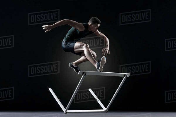 Male athlete clearing hurdle - Royalty-free Stock Photo | Dissolve
