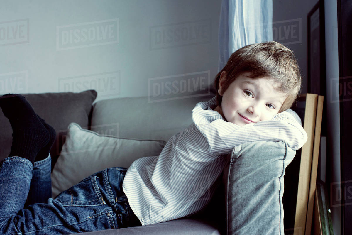 Boy relaxing on sofa, portrait - Royalty-free Stock Photo | Dissolve