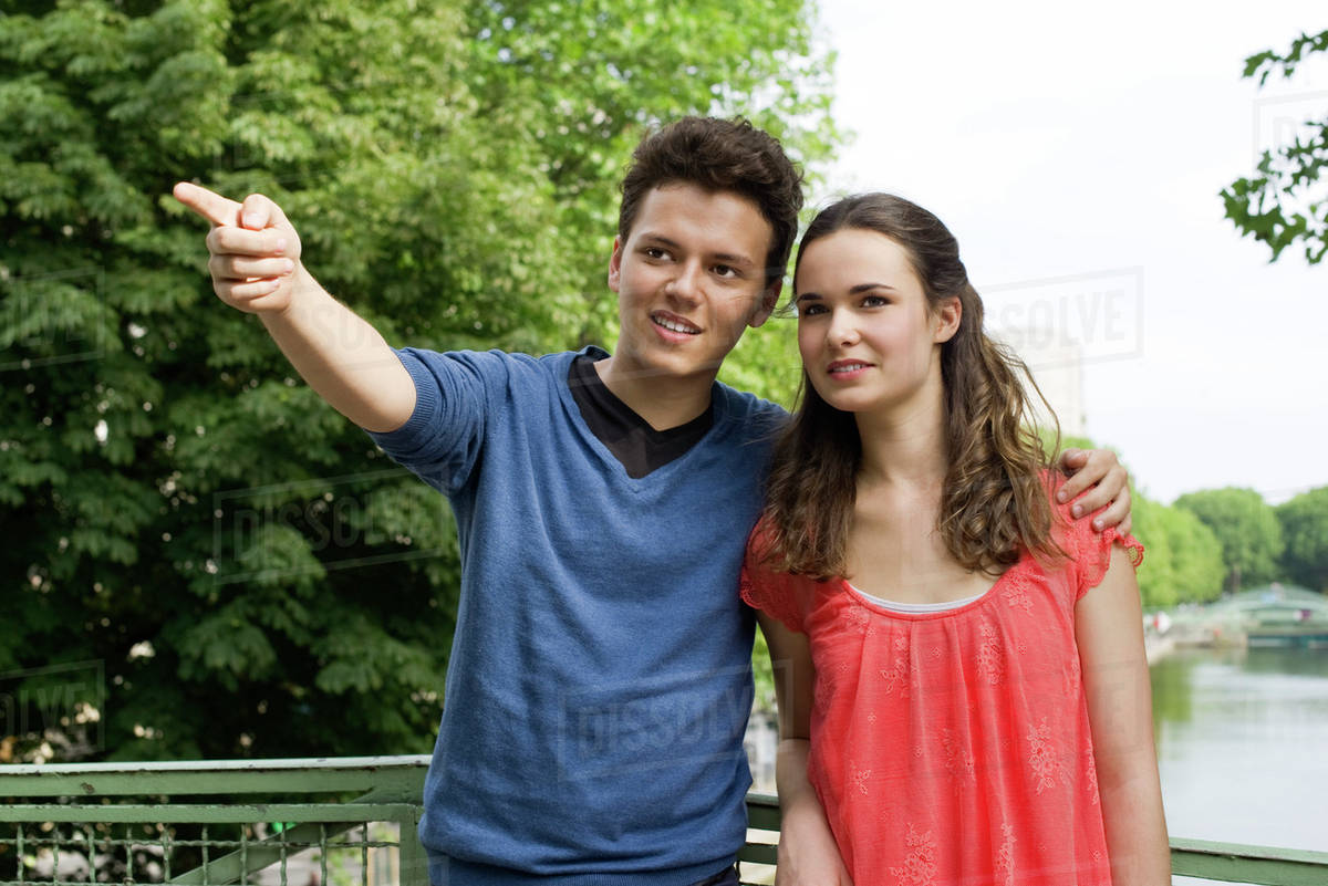 Young couple outdoors, young man pointing into distance, portrait ...