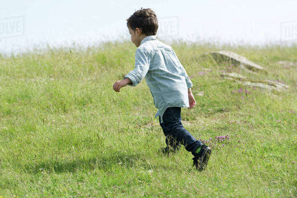 Little boy running in meadow, rear view - Royalty-free Stock Photo ...