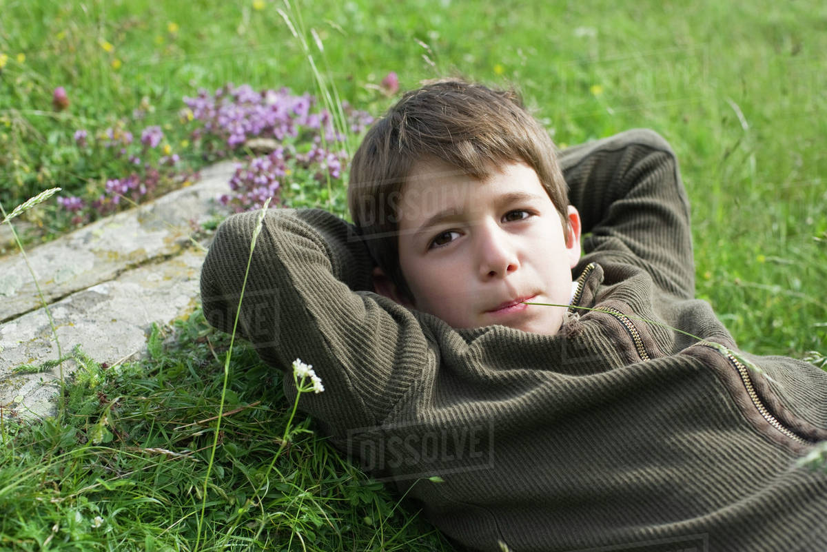 Boy relaxing on grass, portrait - Royalty-free Stock Photo | Dissolve