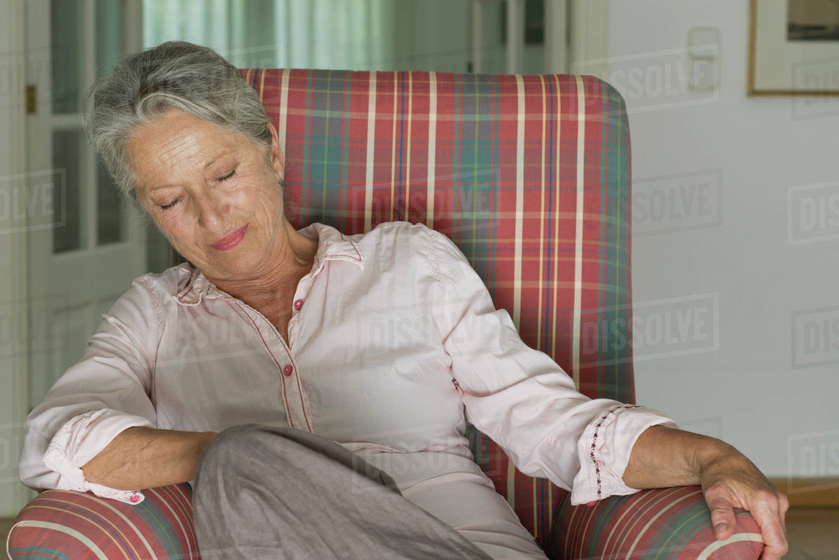 Senior woman napping in armchair - Royalty-free Stock Photo | Dissolve