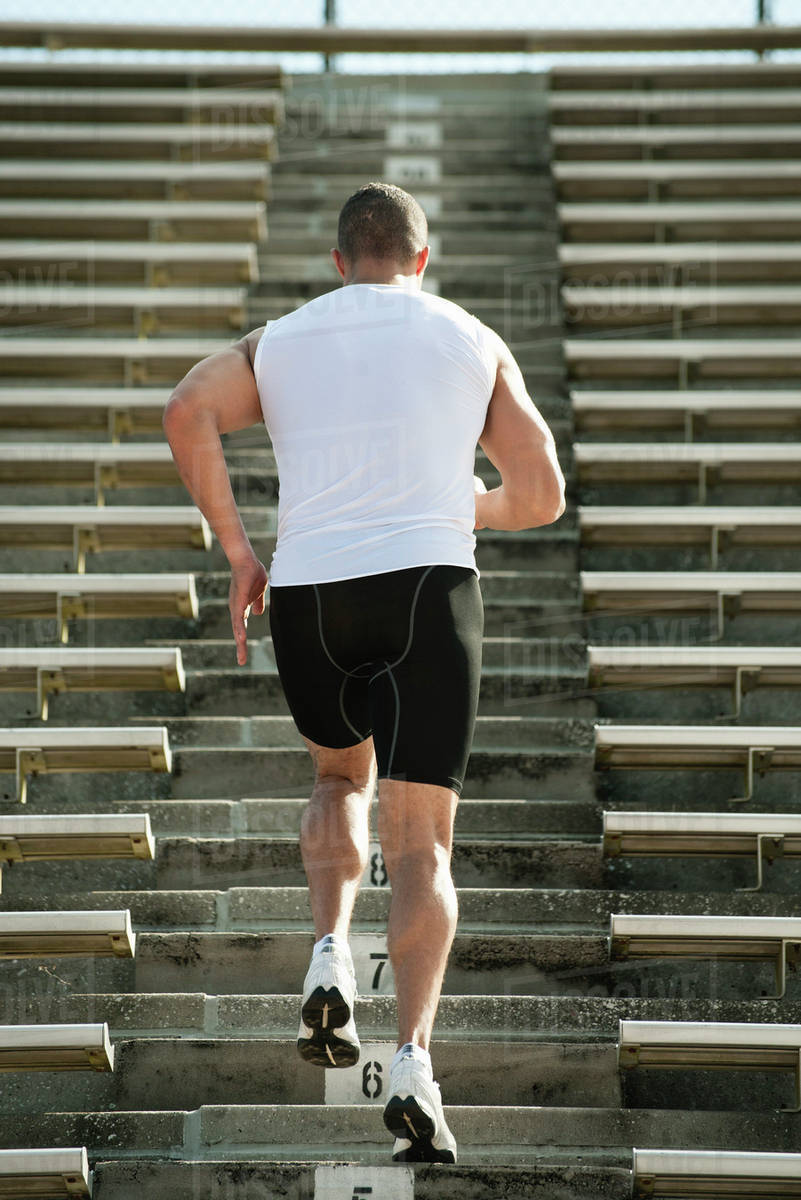 Man running up steps in stadium, rear view - Royalty-free Stock Photo ...