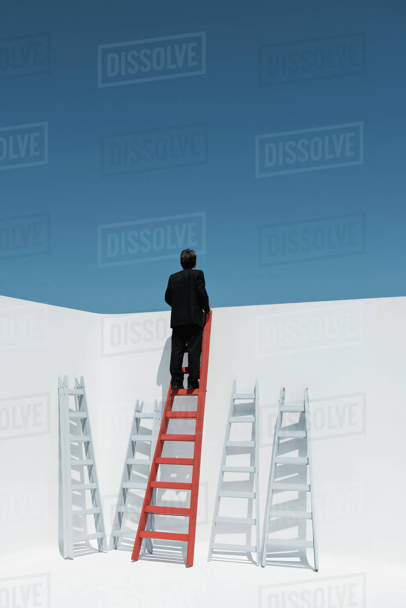 Businessman climbing ladder, rear view - Royalty-free Stock Photo ...