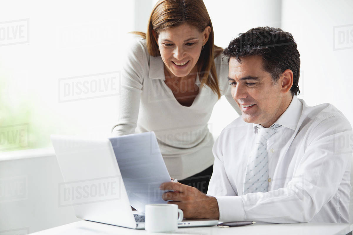 Business colleagues looking at laptop computer together - Stock Photo ...