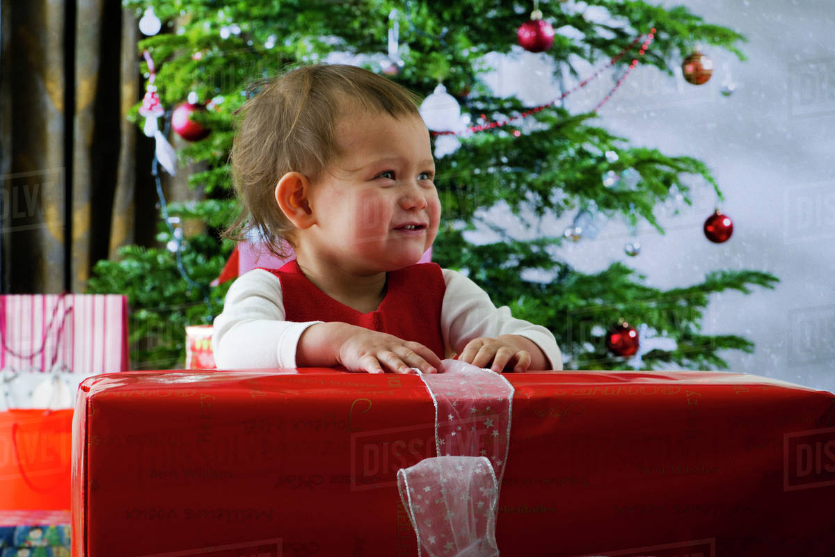 Baby girl opening large Christmas present - Royalty-free Stock Photo ...