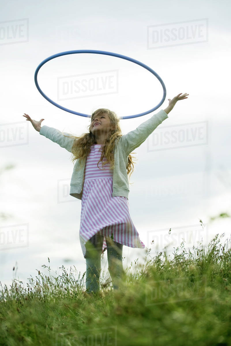 Girl throwing plastic hoop in air - Royalty-free Stock Photo | Dissolve