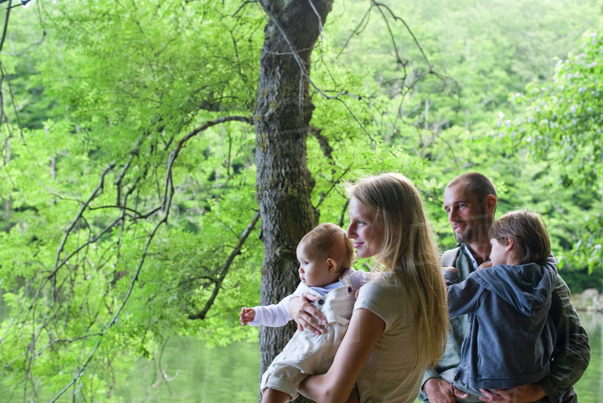 Family with two children in woods - Stock Photo - Dissolve