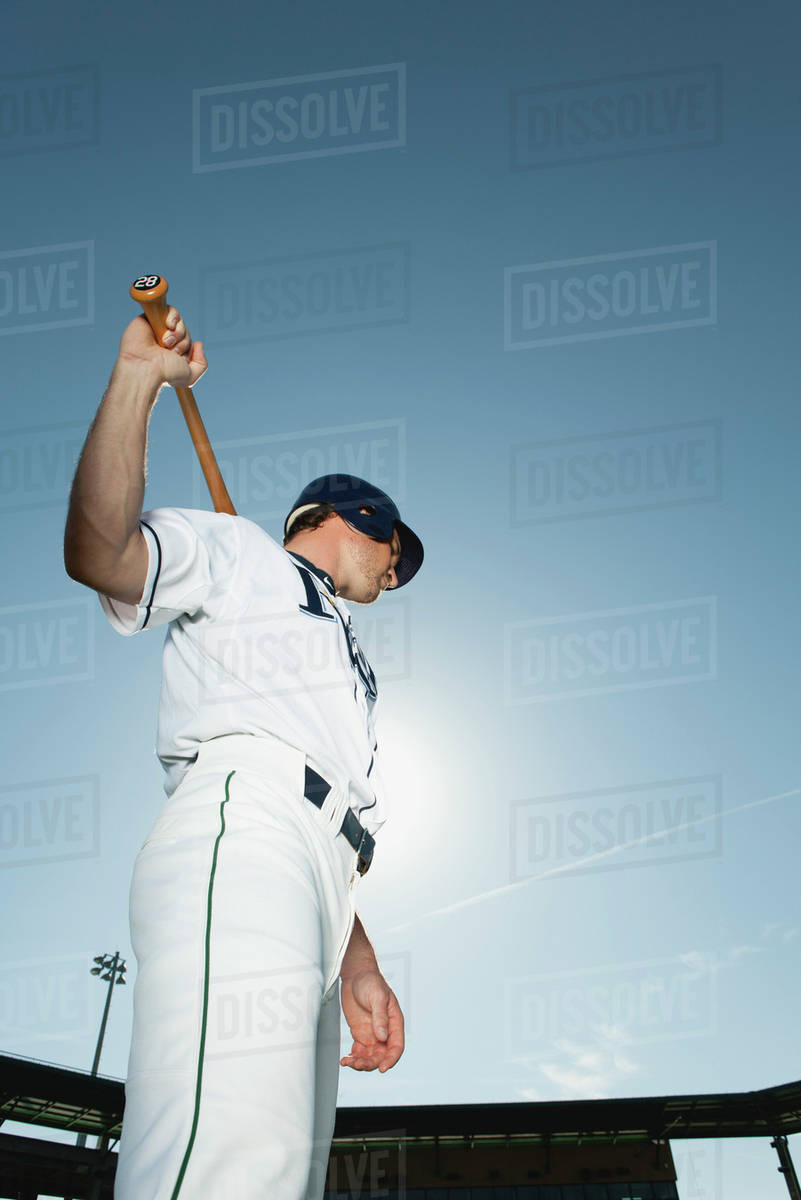 Baseball player holding baseball bat across shoulders - Royalty-free ...