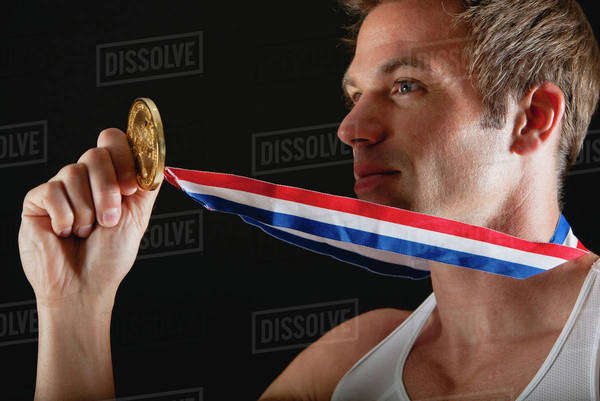 Athlete holding gold medal - Stock Photo - Dissolve