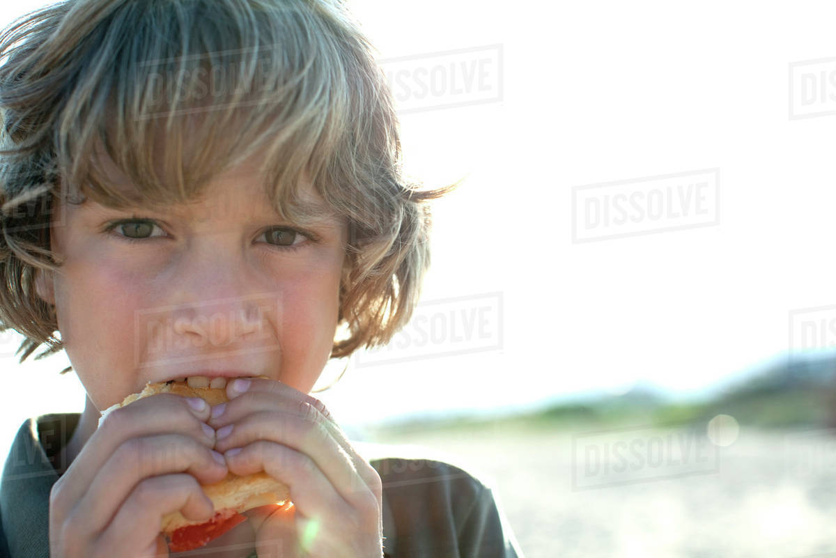 Boy eating sandwich outdoors, portrait - Royalty-free Stock Photo ...