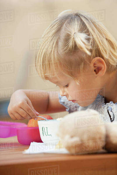 Little girl eating lunch - Royalty-free Stock Photo | Dissolve