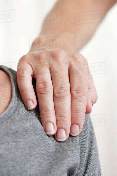 Person's hand on another's shoulder - Stock Photo - Dissolve