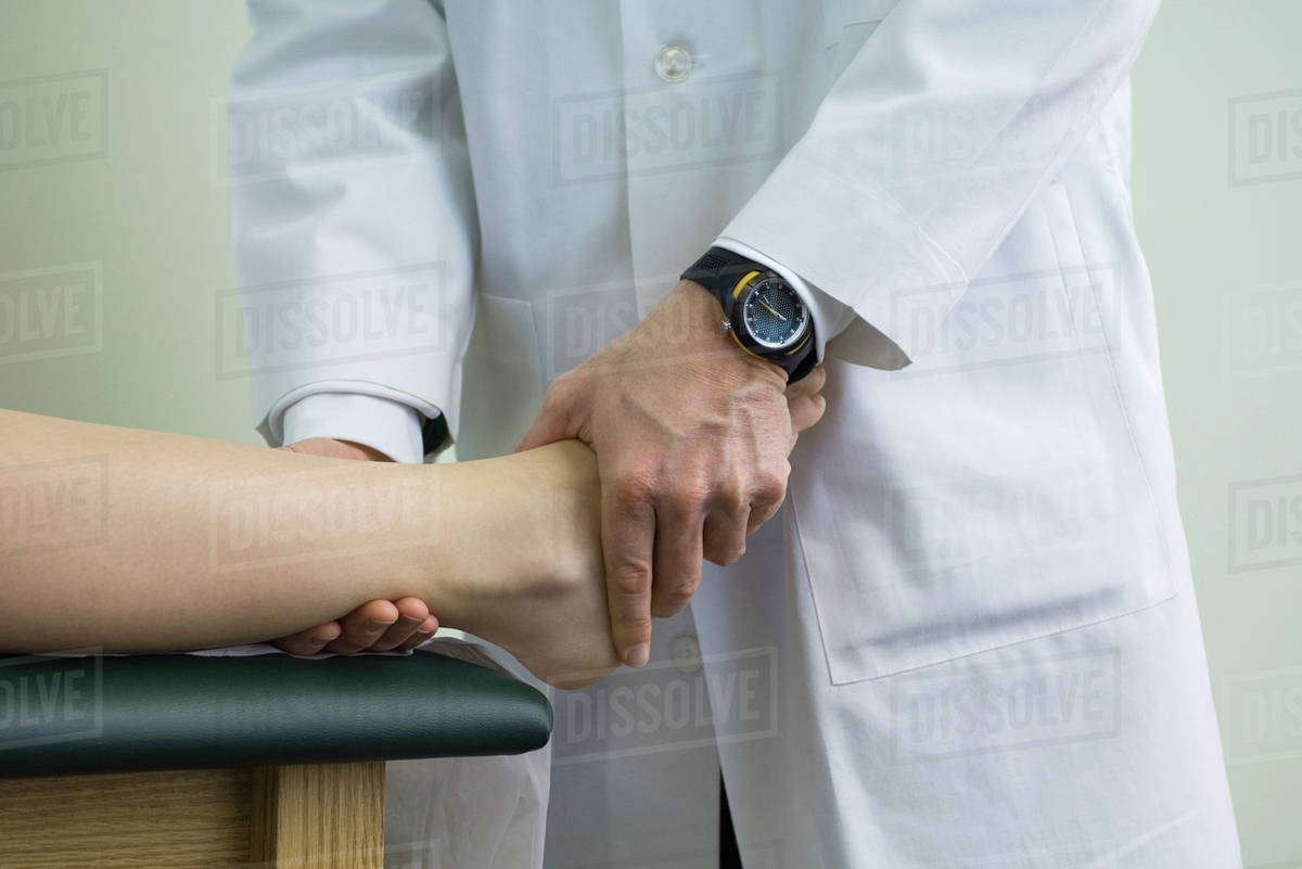 Doctor examining patient's feet and ankle - Royalty-free Stock Photo ...