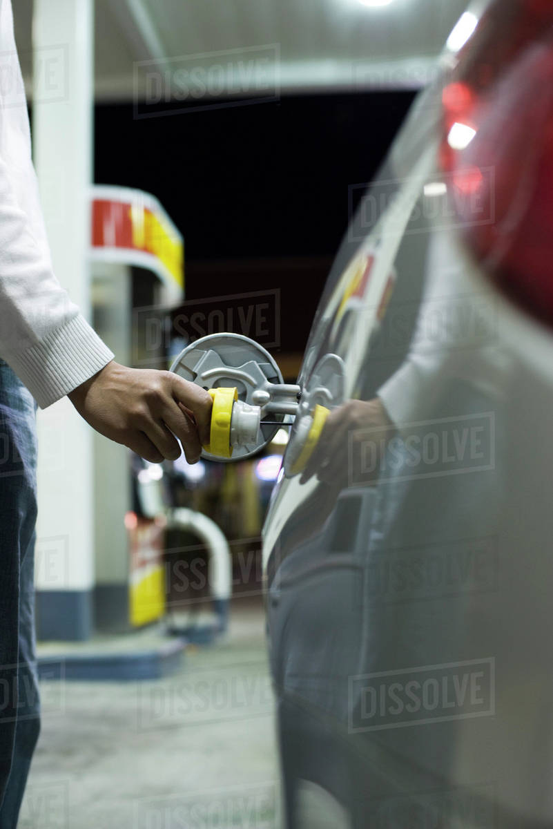 Driver opening gas tank to refuel at gas station - Stock Photo - Dissolve