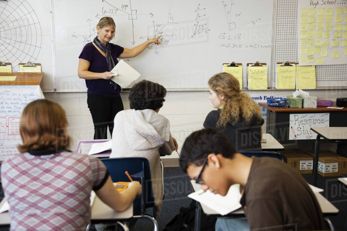 Woman teaching mathematics to high school students - Stock Photo - Dissolve