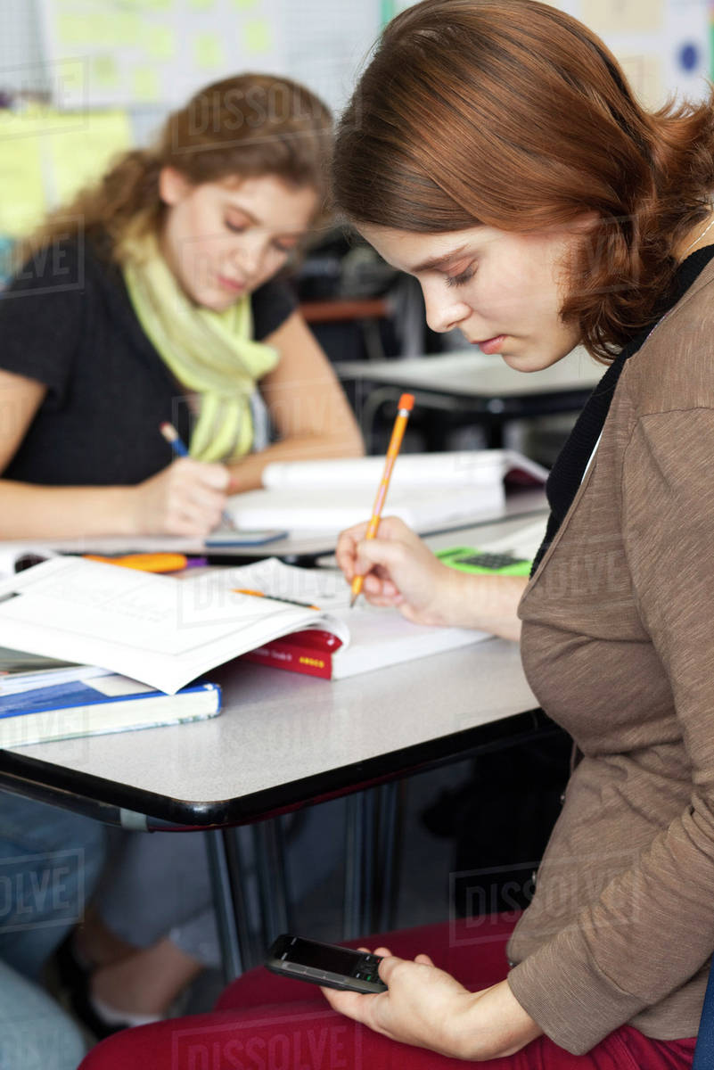 Young woman text messaging while in class - Royalty-free Stock Photo ...