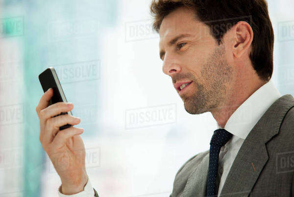 Businessman looking at cell phone - Royalty-free Stock Photo | Dissolve