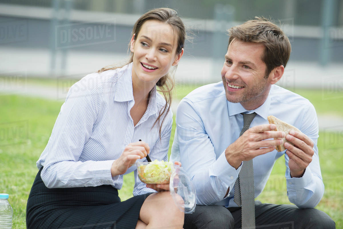 Coworkers having lunch together outdoors - Stock Photo - Dissolve