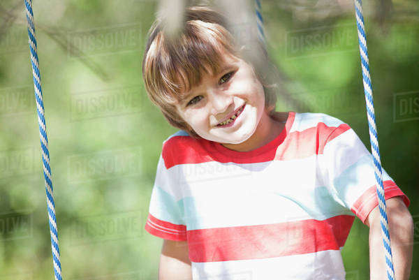 Boy on swing, portrait - Royalty-free Stock Photo | Dissolve
