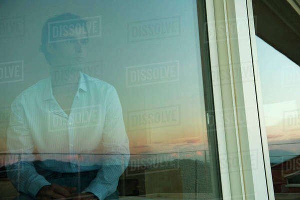Man looking through window - Stock Photo - Dissolve