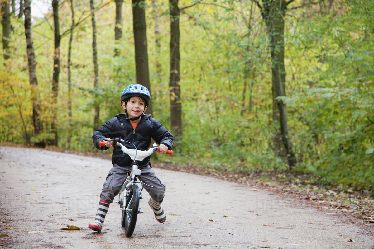 Boy riding bike, smiling at camera - Royalty-free Stock Photo | Dissolve