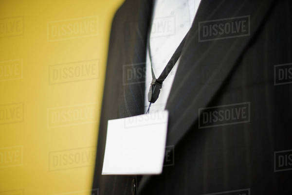 Man in suit wearing blank nametag around neck, cropped - Stock Photo ...