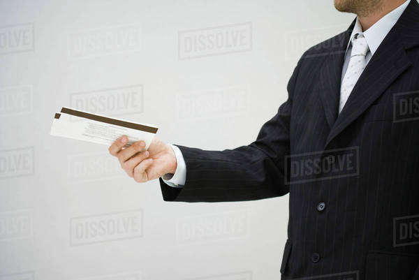 Man in suit holding out tickets, side view - Stock Photo - Dissolve