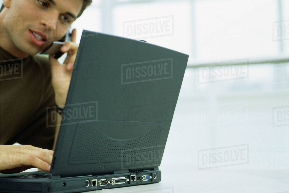 Man phoning, using laptop computer, low angle view - Royalty-free Stock ...