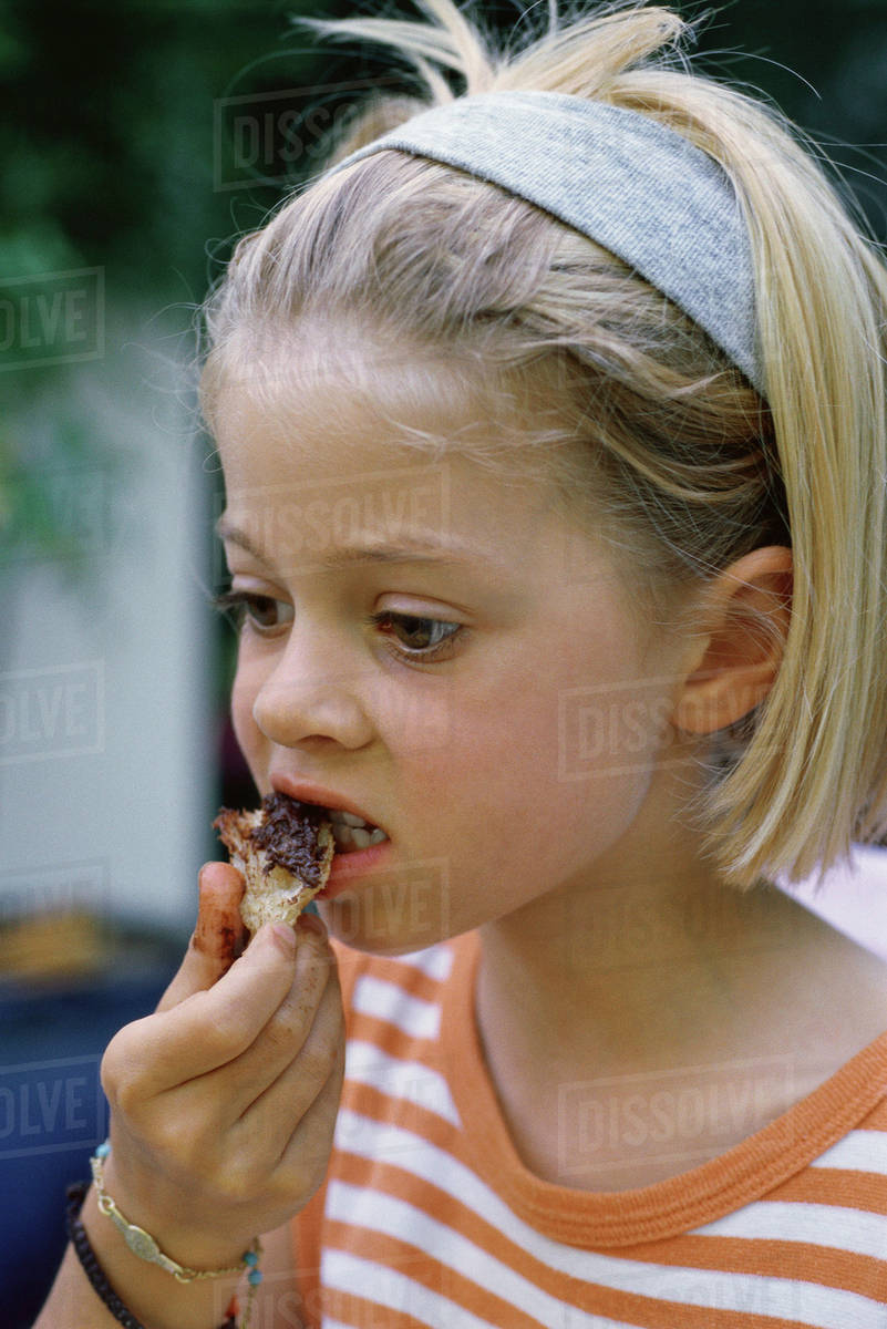 Little girl eating snack - Royalty-free Stock Photo | Dissolve