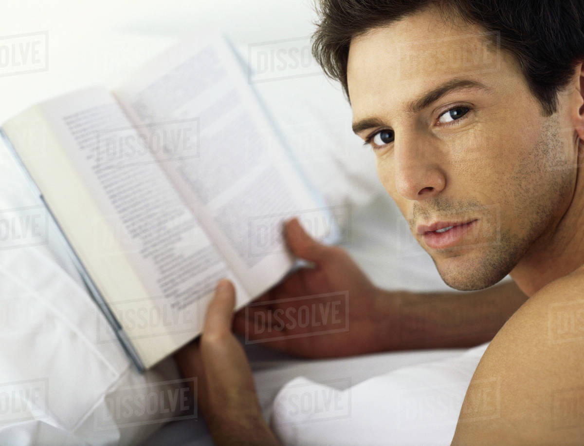 Man holding book, looking over shoulder at camera - Royalty-free Stock ...