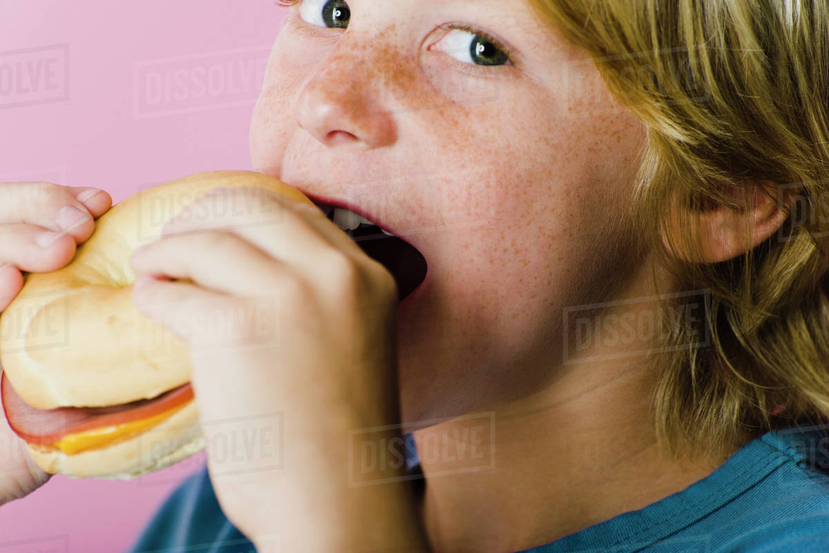 Boy eating ham and cheese sandwich - Royalty-free Stock Photo | Dissolve