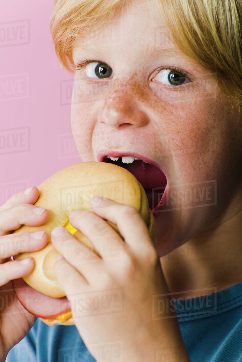Boy eating ham and cheese sandwich - Royalty-free Stock Photo | Dissolve