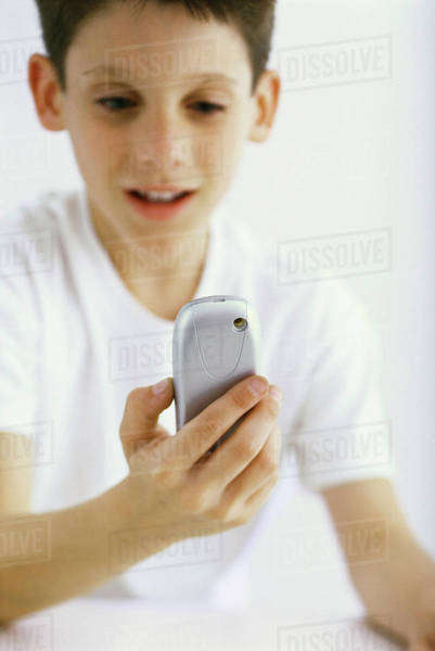 Boy looking at cell phone - Royalty-free Stock Photo | Dissolve