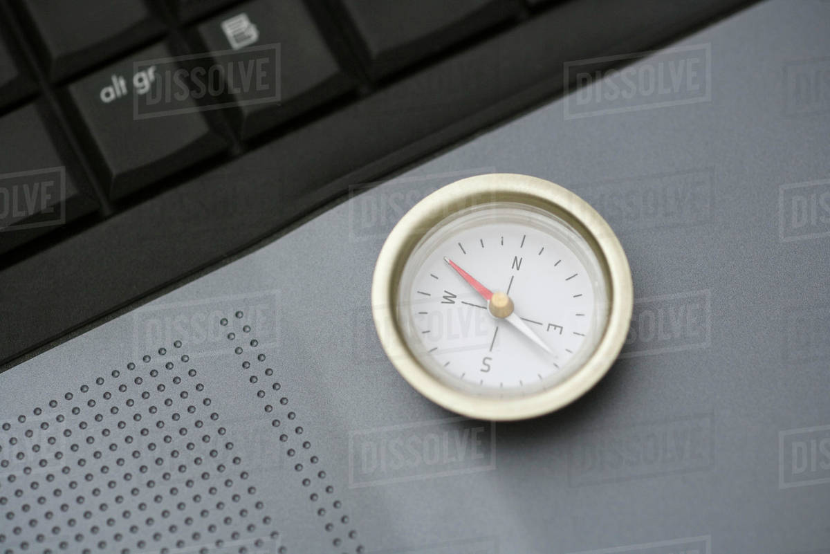 Compass on laptop computer, close-up - Stock Photo - Dissolve