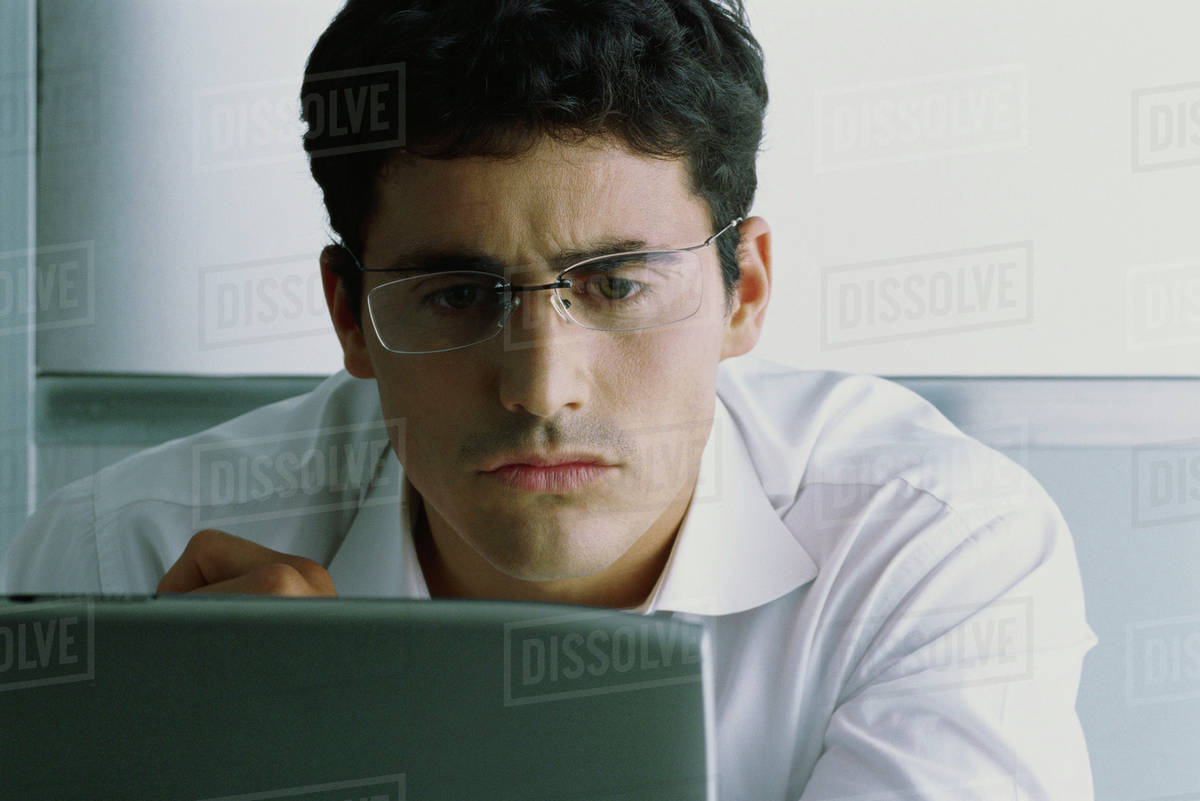 Man using computer, frowning - Royalty-free Stock Photo | Dissolve