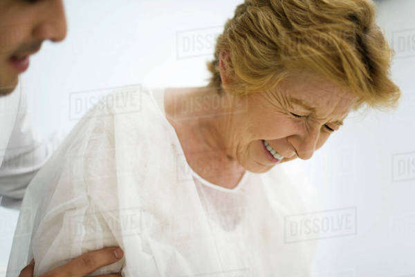 Doctor consoling upset patient, cropped - Stock Photo - Dissolve