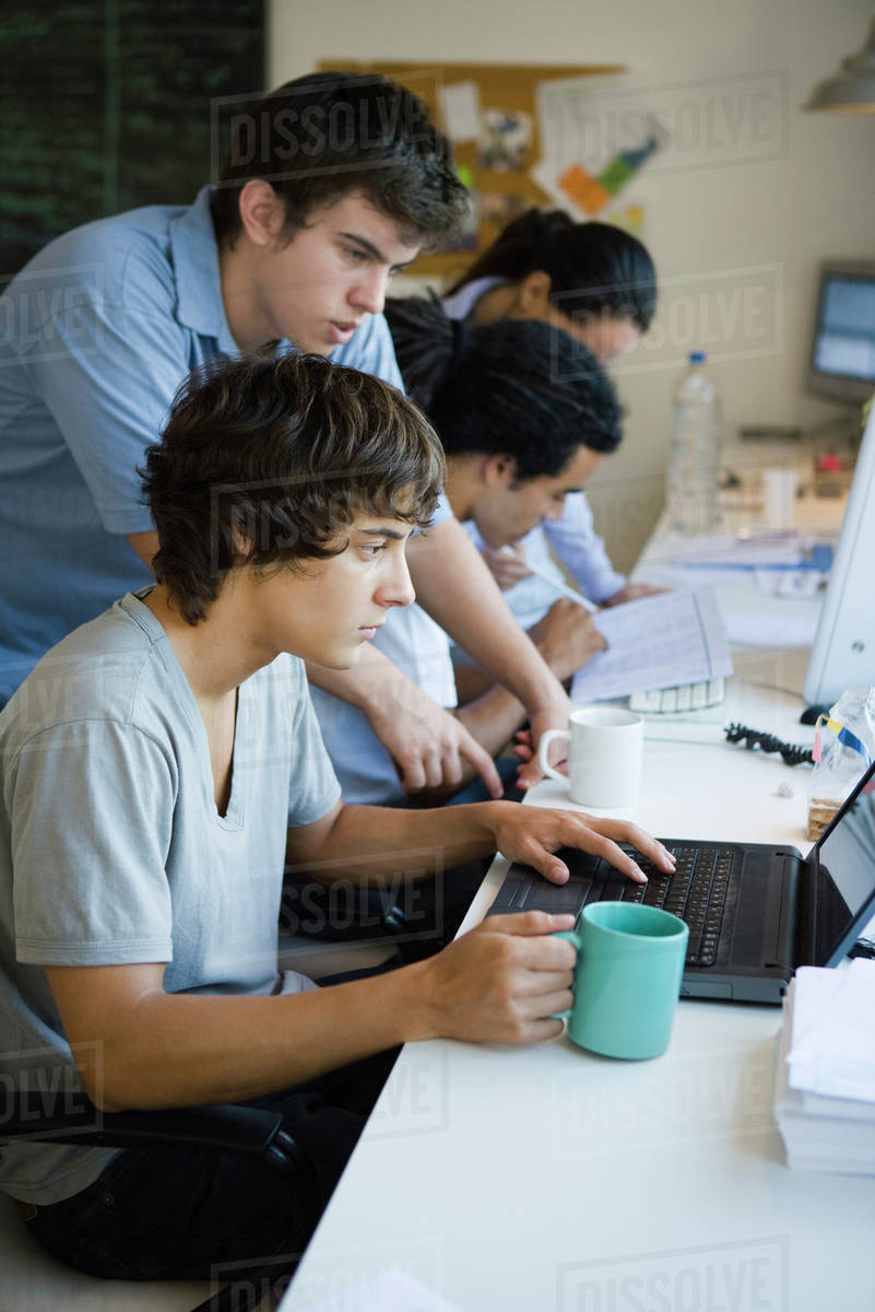 Male college students working together using laptop computer - Royalty ...