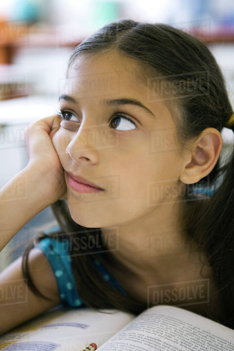 Female elementary school student daydreaming in class - Royalty-free ...