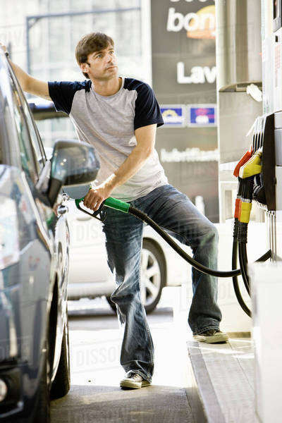 Man refueling vehicle at gas station - Royalty-free Stock Photo | Dissolve