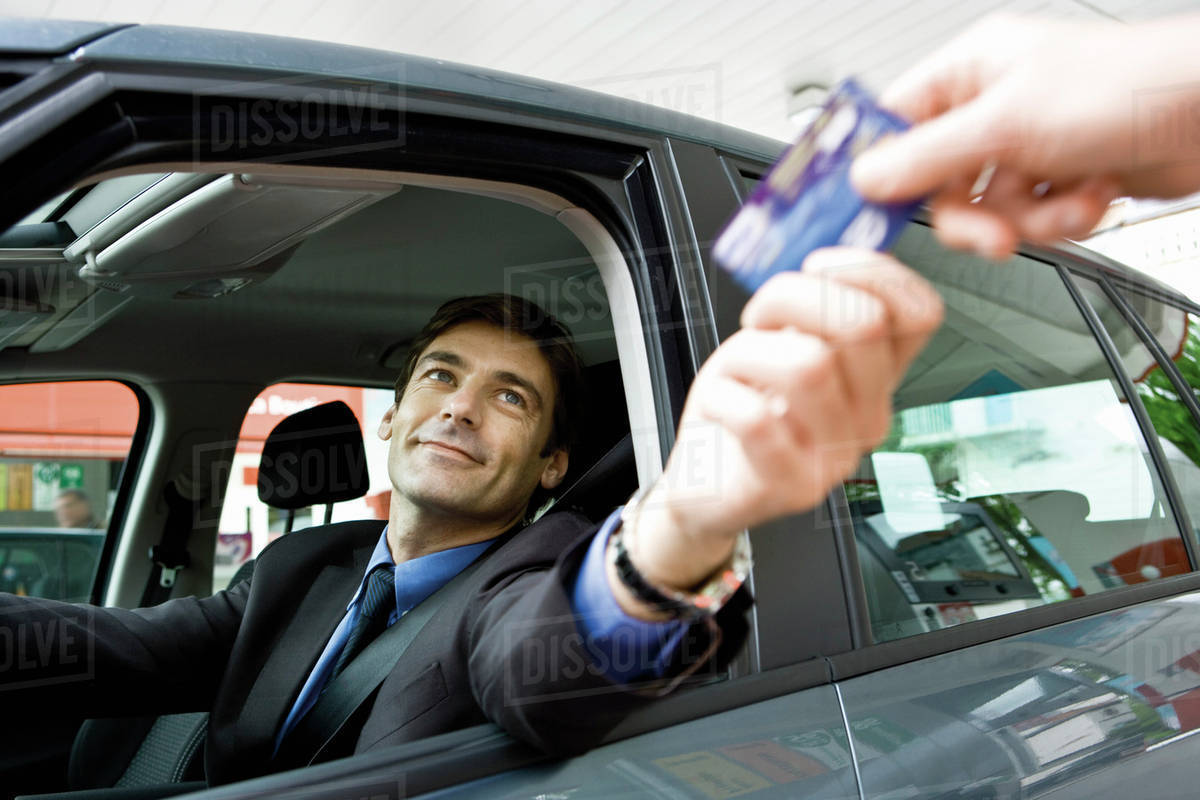 Customer in drive-thru handing credit card to check-out window clerk ...