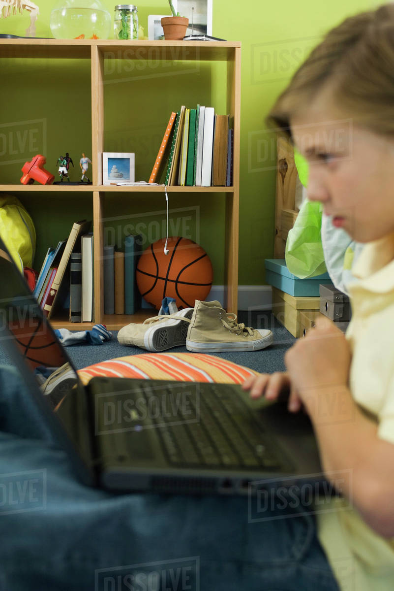 Preteen boy using laptop computer - Royalty-free Stock Photo | Dissolve