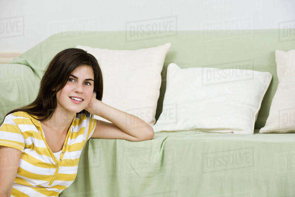 Teenage girl leaning on sofa, portrait - Royalty-free Stock Photo ...
